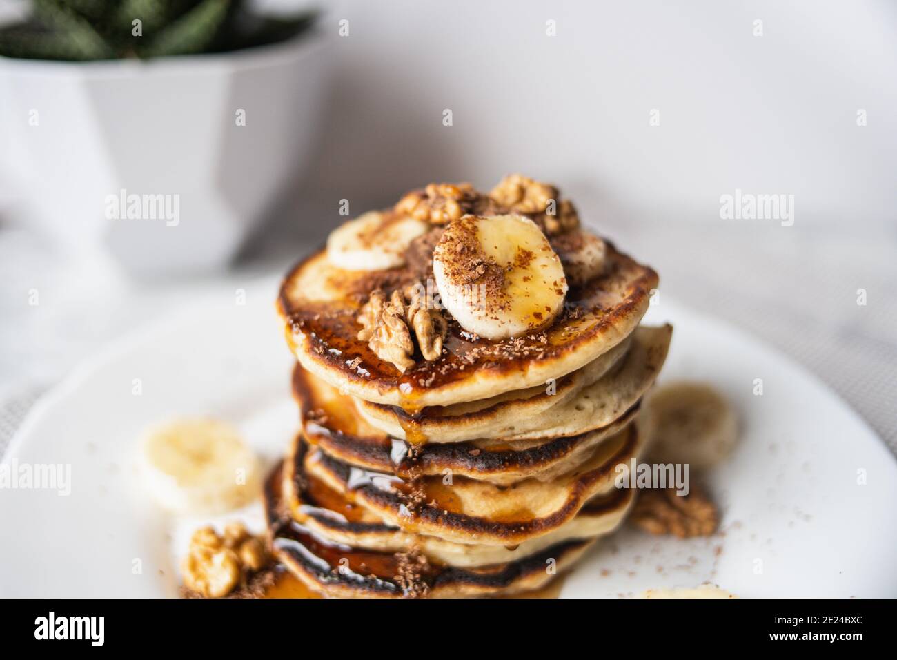 Delicious homemade banana pancake stack with nuts and maple syrup Stock ...