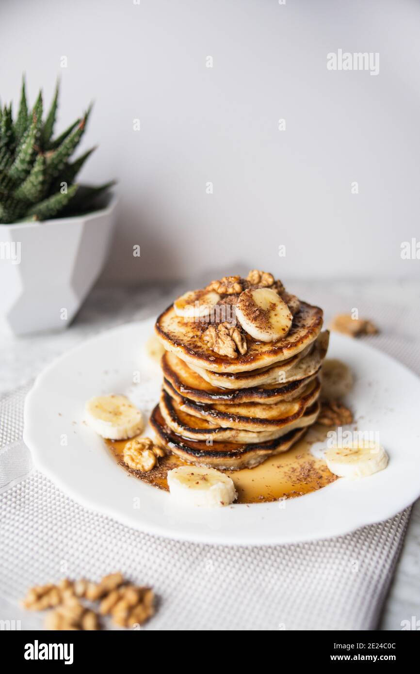 Delicious homemade banana pancake stack with nuts and maple syrup Stock ...