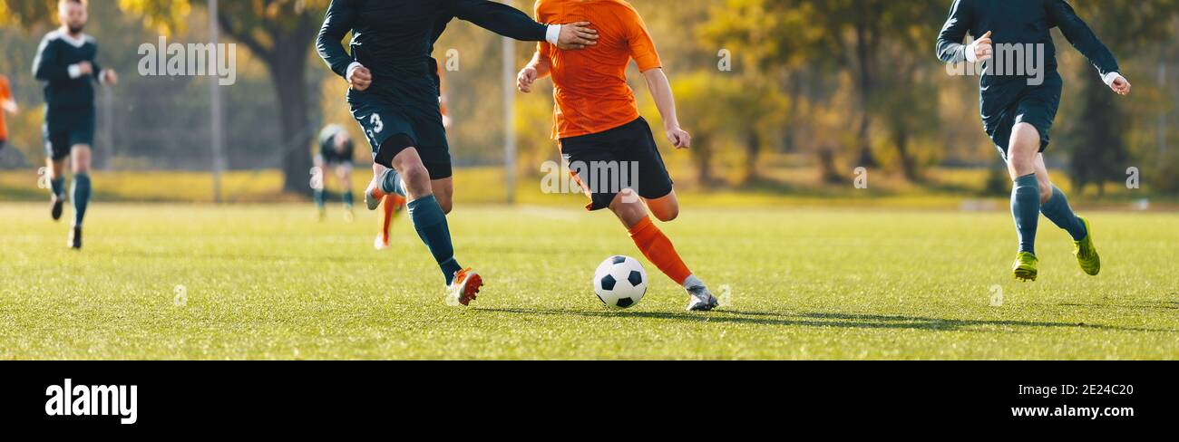 Horizontal image of football players running in a duel on a tournament ...