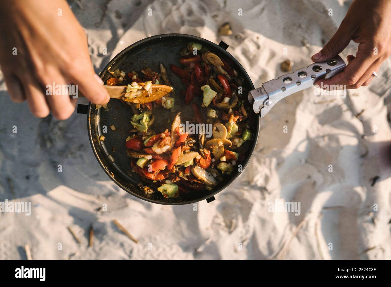 Hand with wooden spoon mixing food in saucepan Stock Photo - Alamy