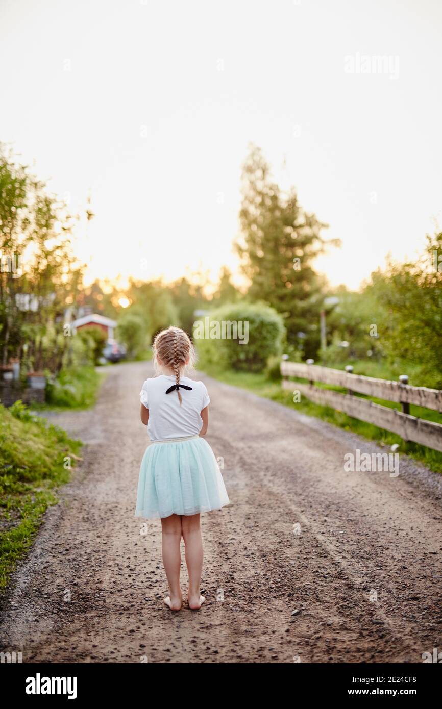 Girl standing on dirt road Stock Photo - Alamy