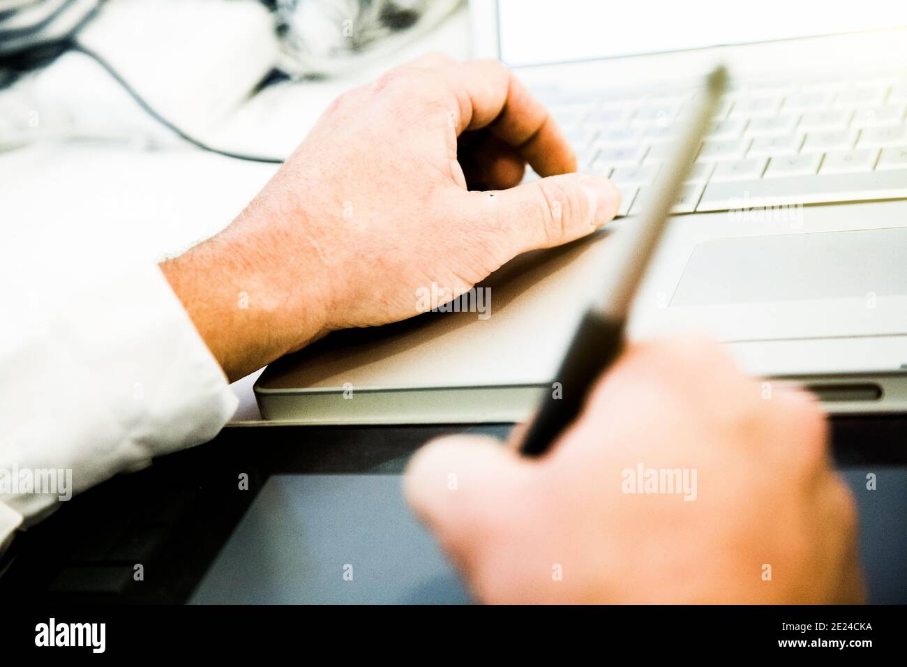 Graphic designer using laptop and drawing board Stock Photo - Alamy