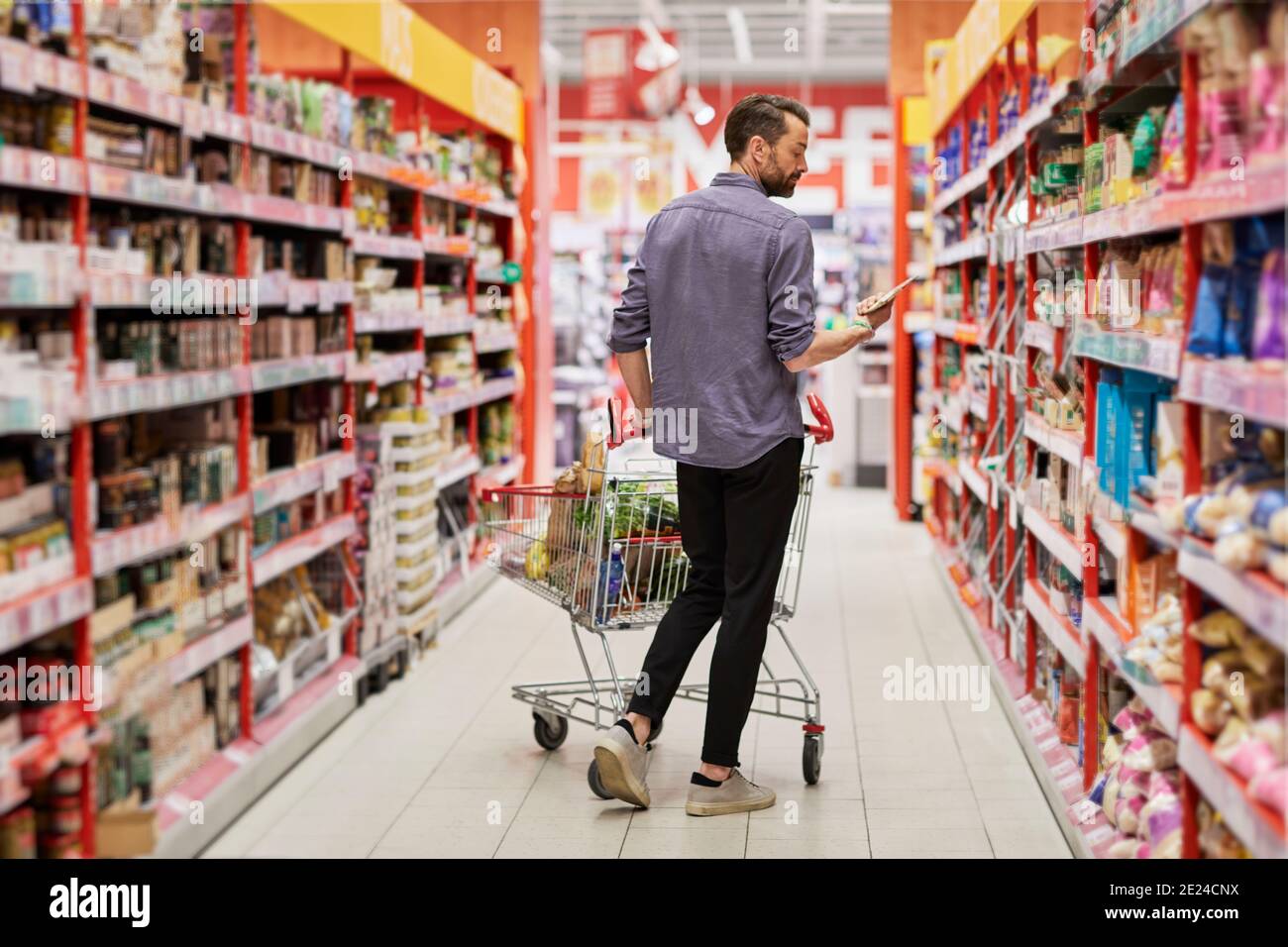 Man doing shopping in supermarket Stock Photo - Alamy