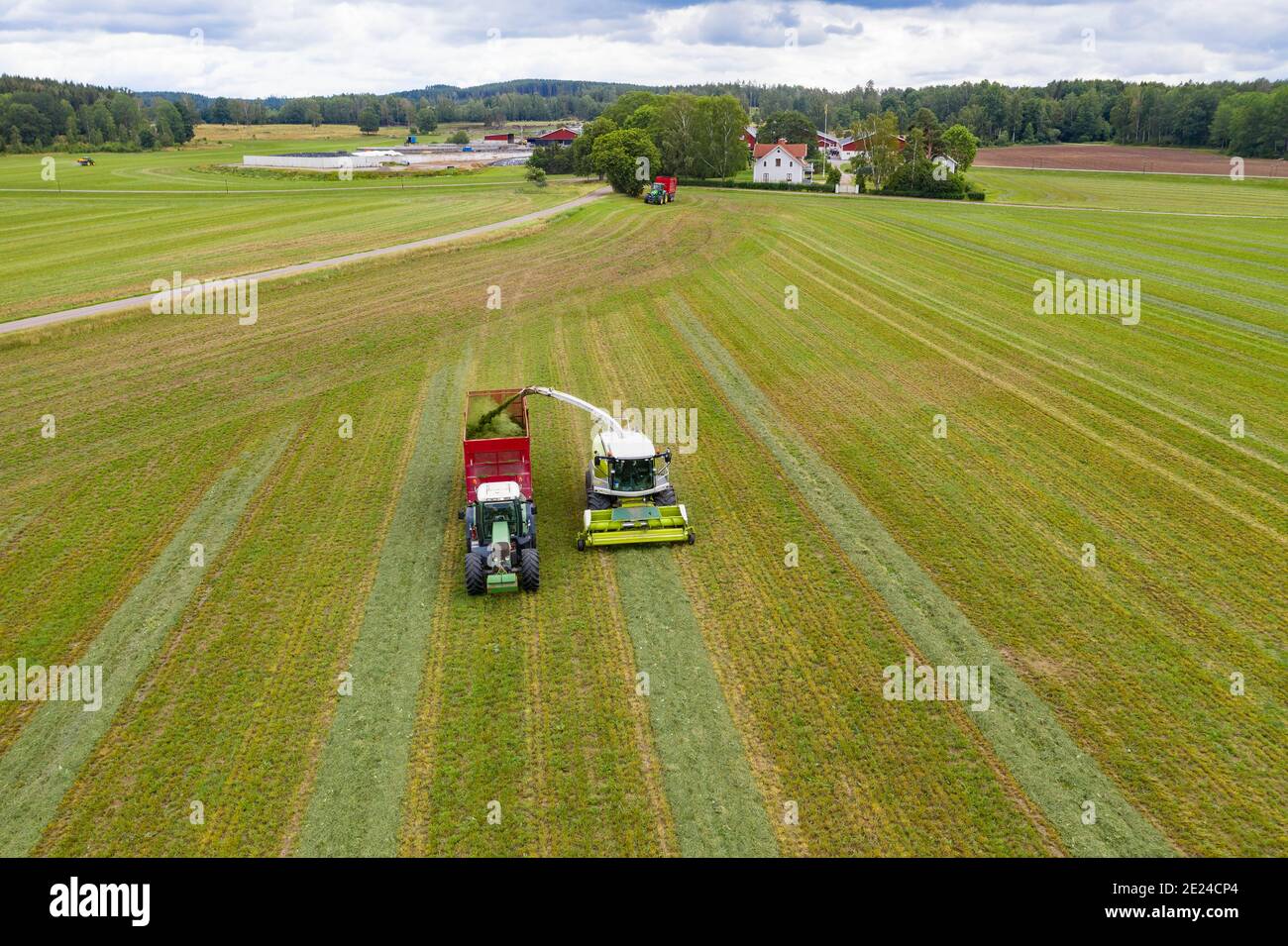 Harvester and tractor on field Stock Photo - Alamy