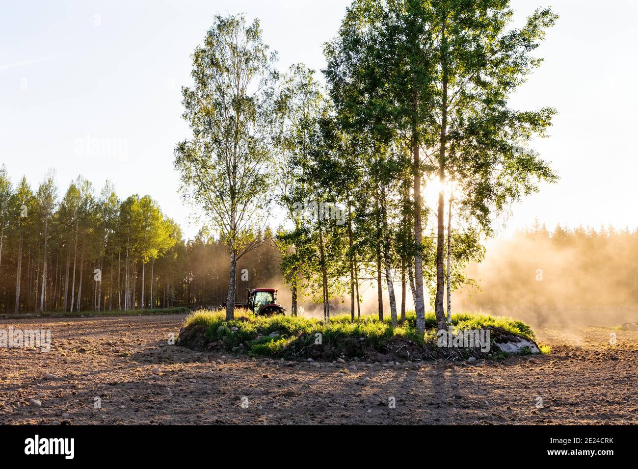 Tractor harrowing field Stock Photo - Alamy