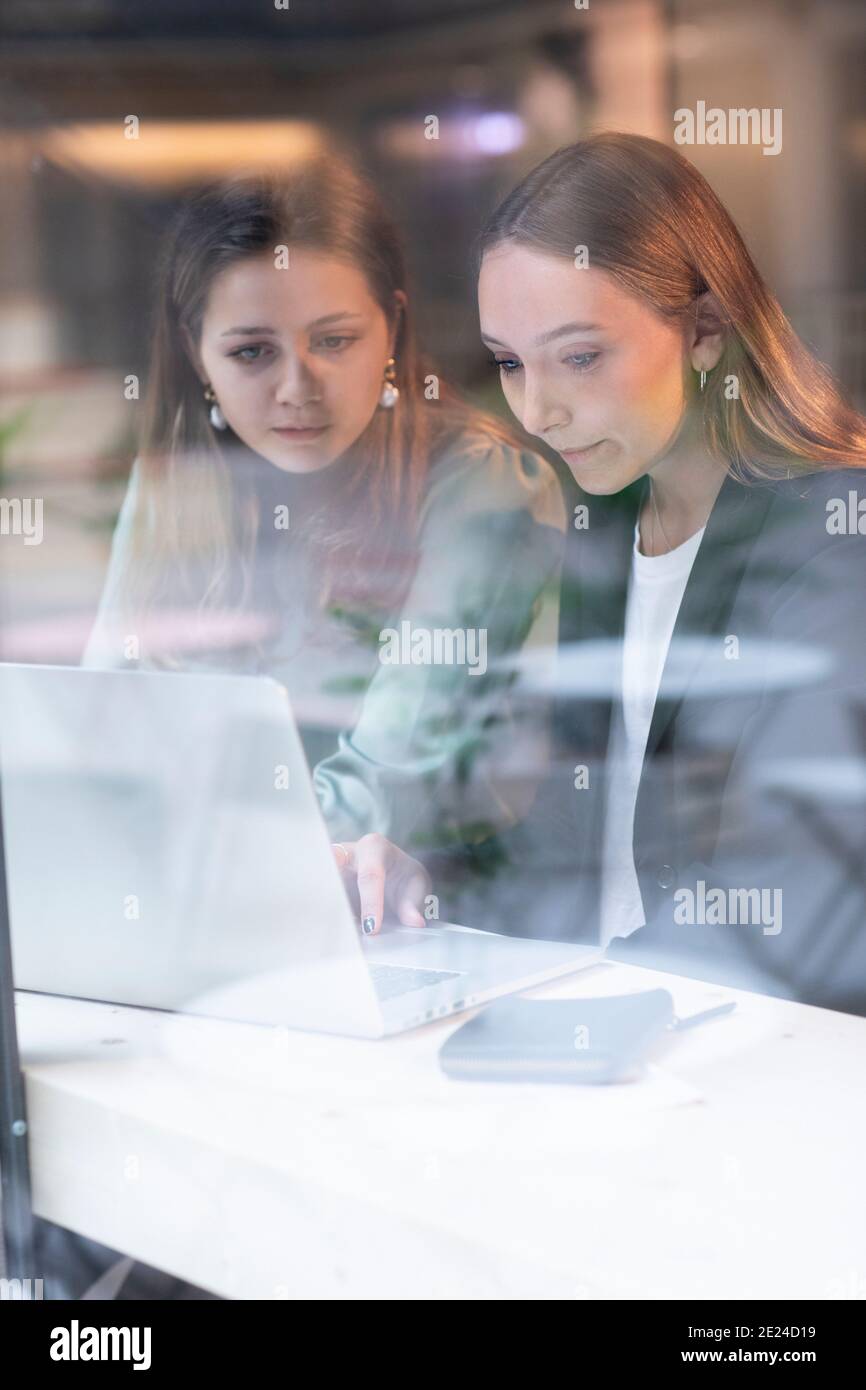 Female coworkers using laptop in cafe Stock Photo - Alamy