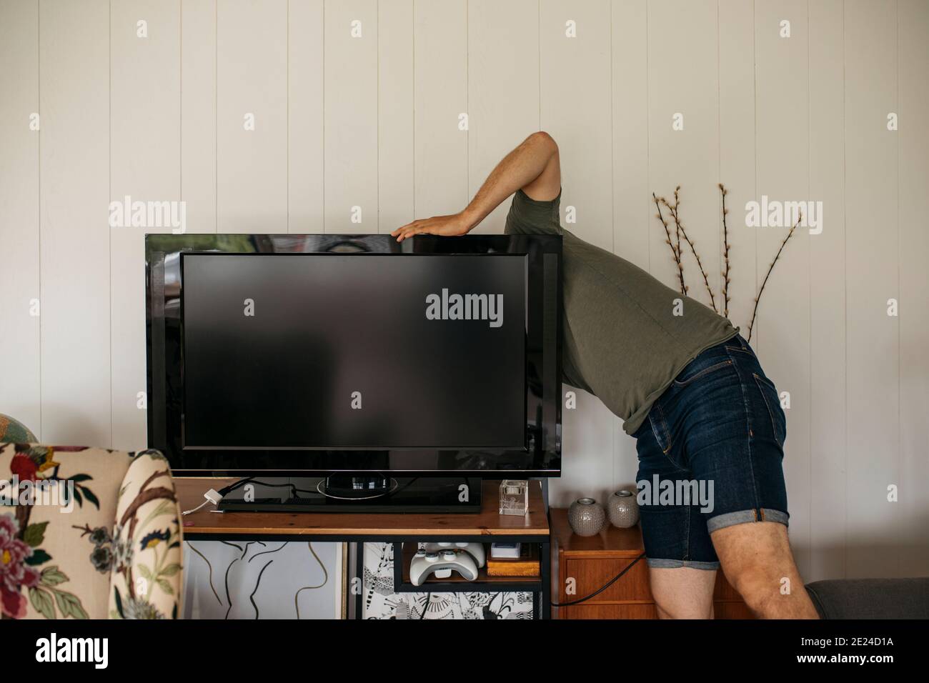 Man checking back of TV Stock Photo - Alamy