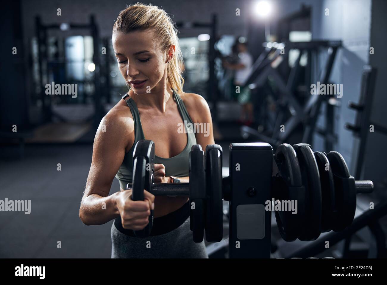 Female returning a disk weight to its place Stock Photo - Alamy