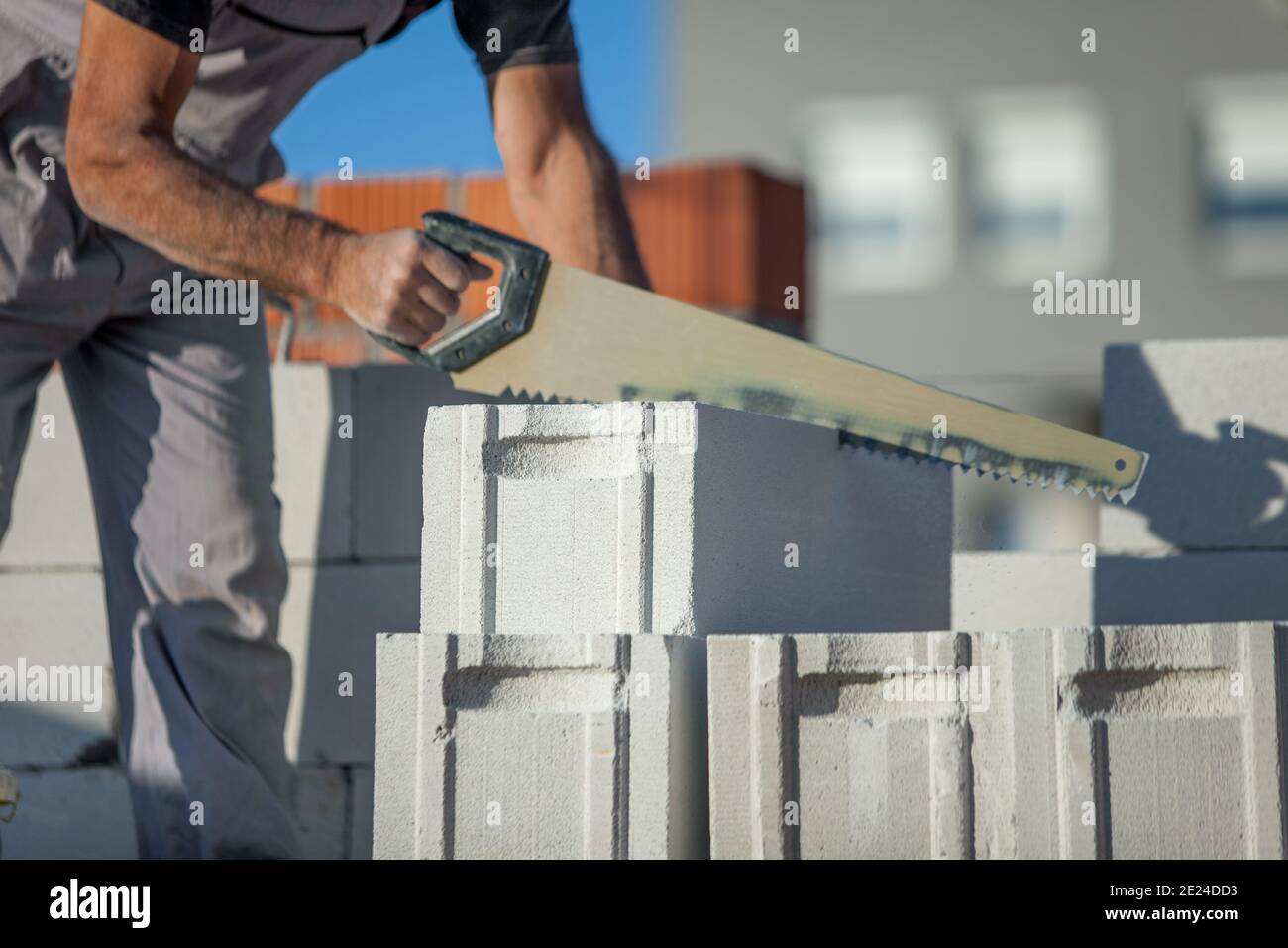 Man builder sawing a gas-silicate block Stock Photo - Alamy