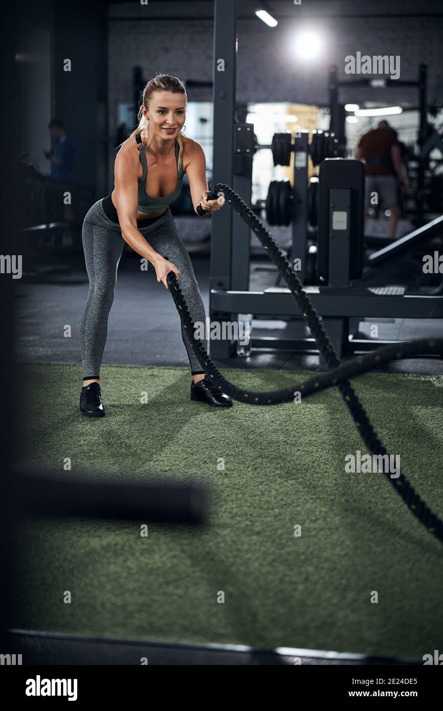 Joyful female creating a wave with the ropes Stock Photo - Alamy