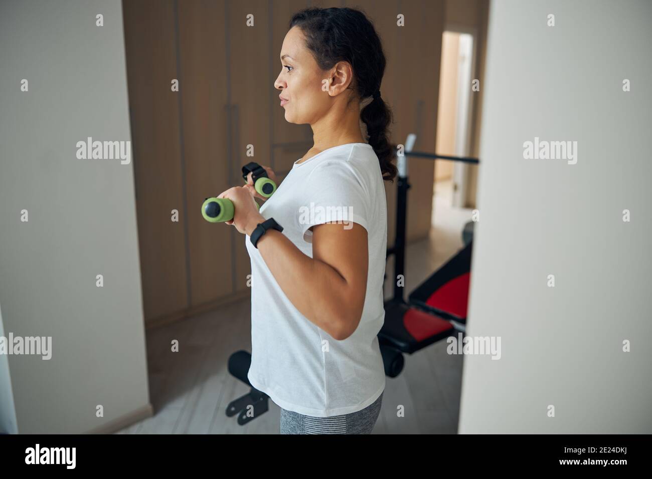Athletic female performing an arm exercise indoors Stock Photo - Alamy