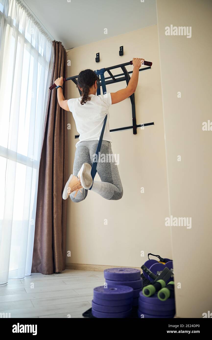 Female athlete performing pull-ups with an overhead grip Stock Photo ...