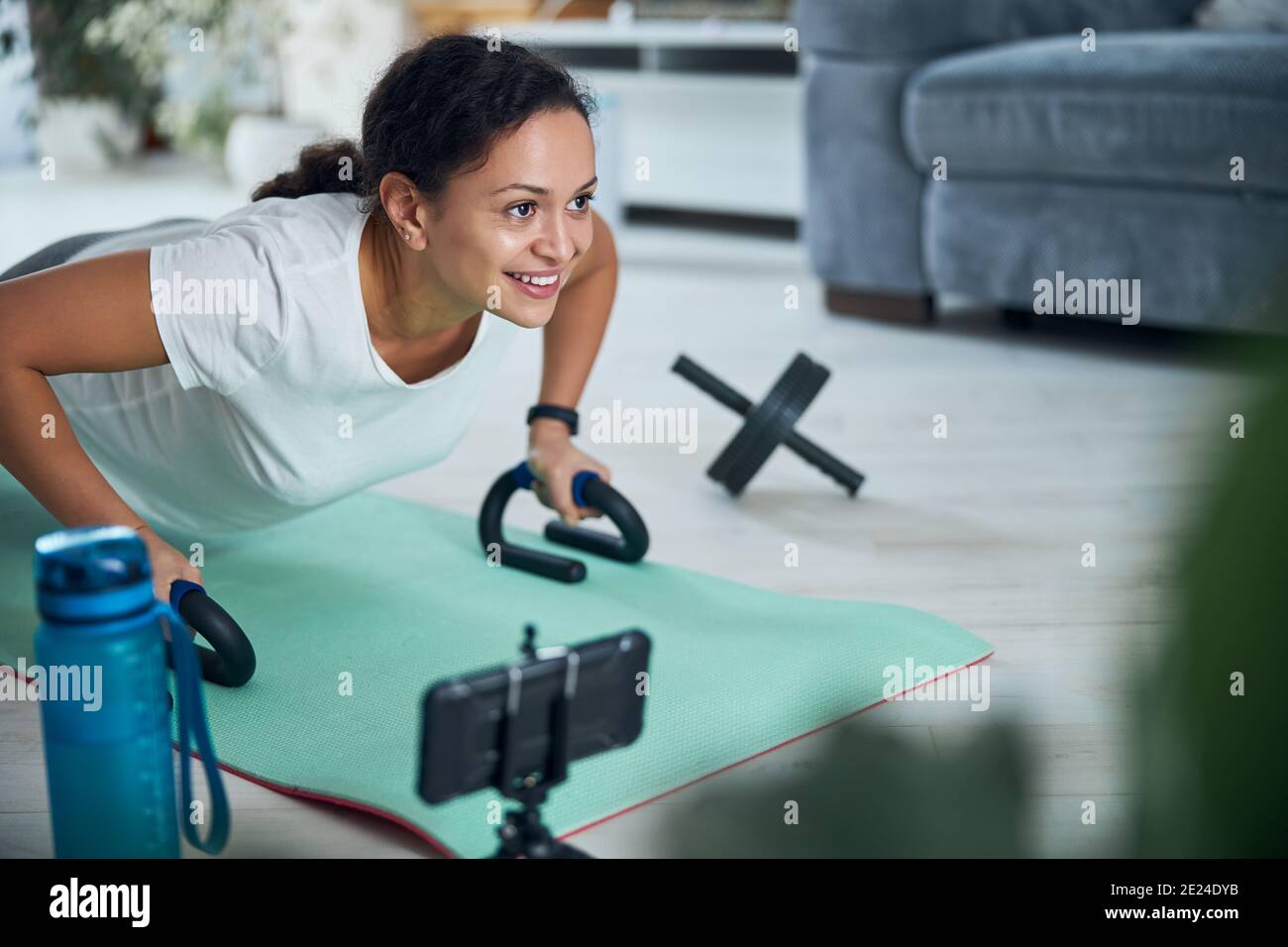 Beautiful smiling woman performing a strength exercise Stock Photo - Alamy