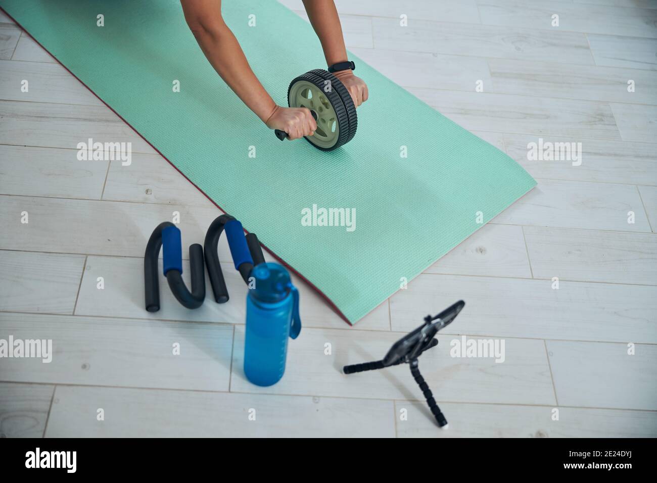 Female hands rolling the ab wheel forward Stock Photo - Alamy