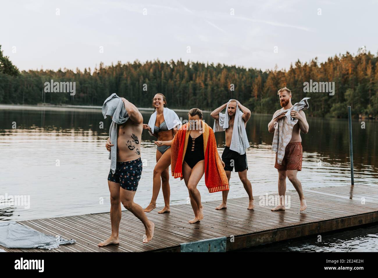 Smiling friends walking on jetty Stock Photo - Alamy