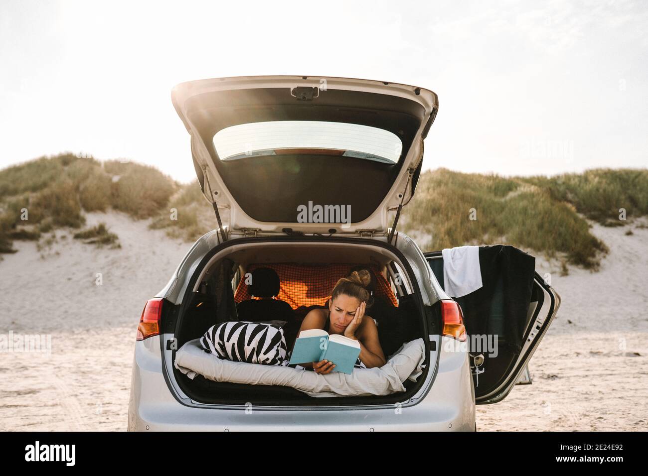 Woman in car reading book Stock Photo - Alamy