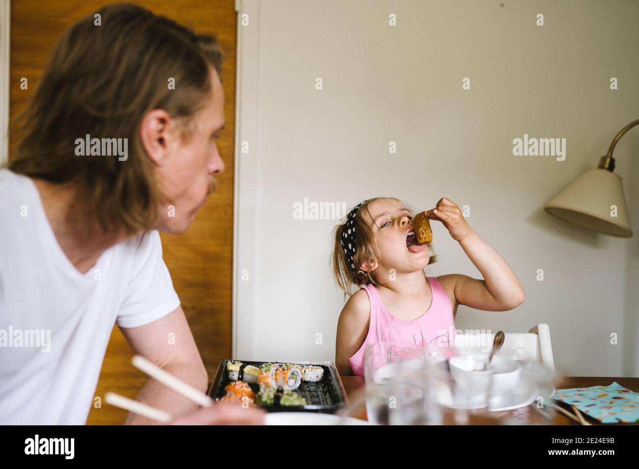 Girl eating at table Stock Photo - Alamy