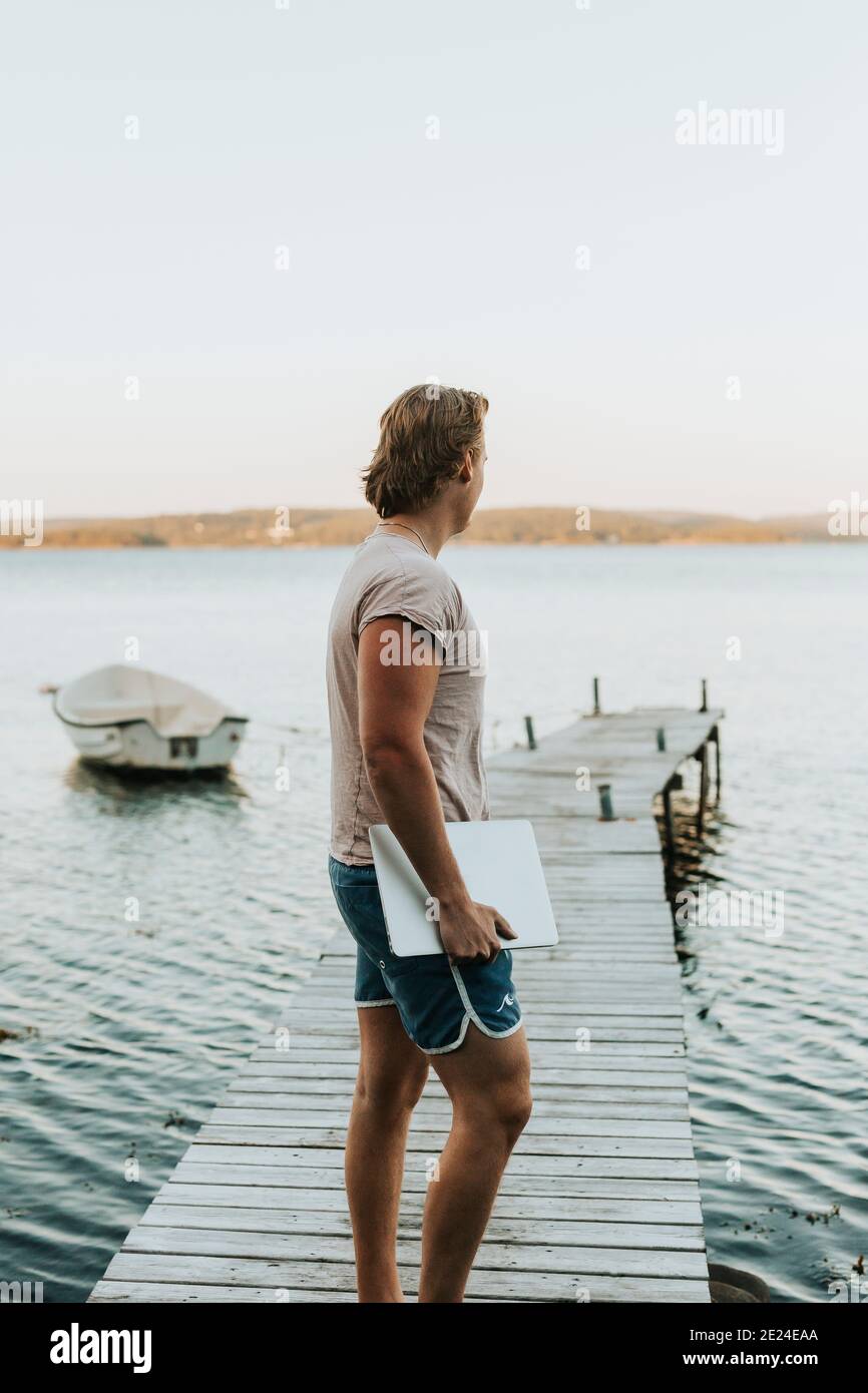 Young man standing jetty hi-res stock photography and images - Alamy
