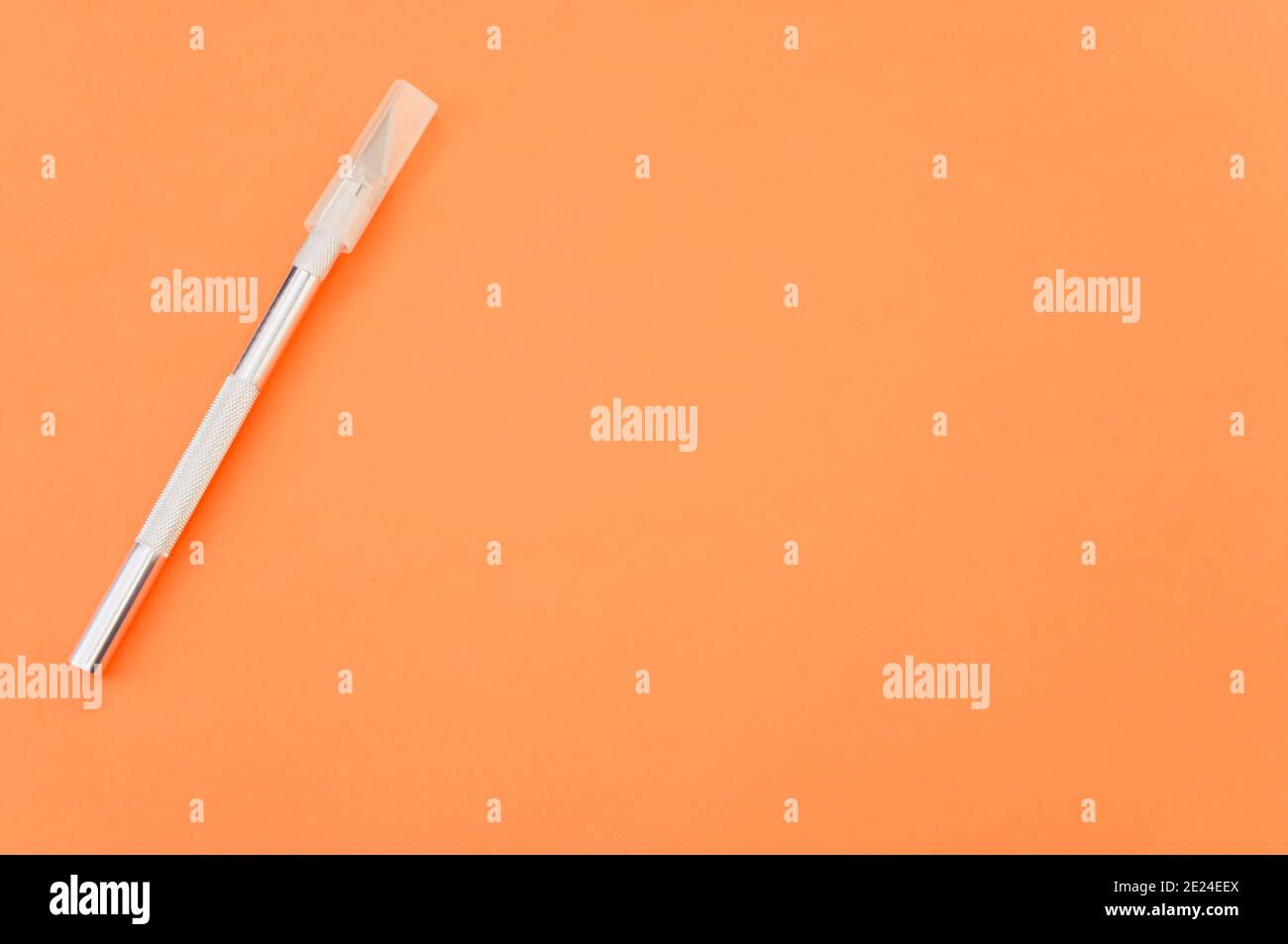 Top view of metallic scalpel with cap isolated on orange background ...