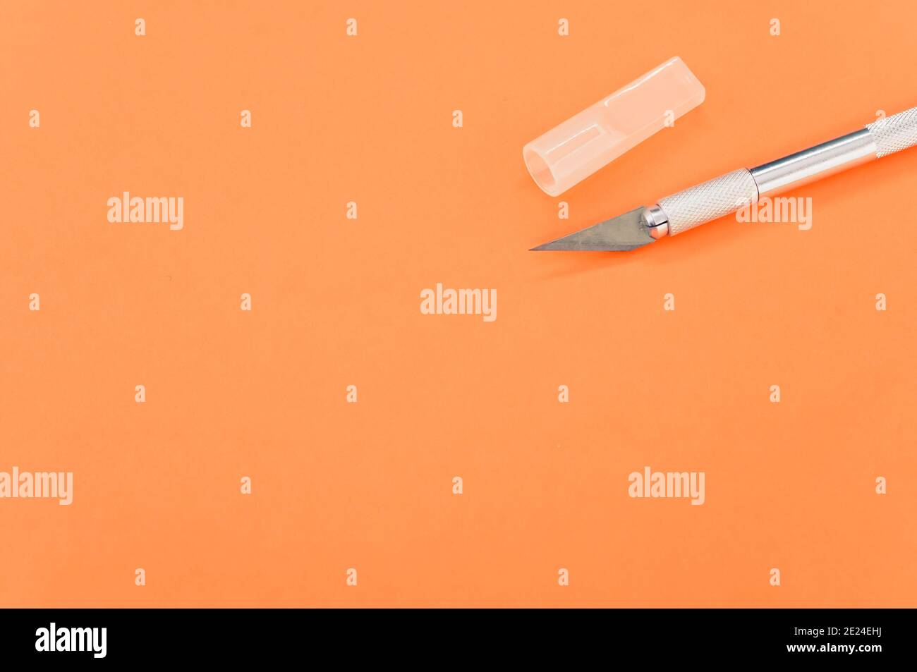 Top view of metallic scalpel with cap isolated on orange background ...