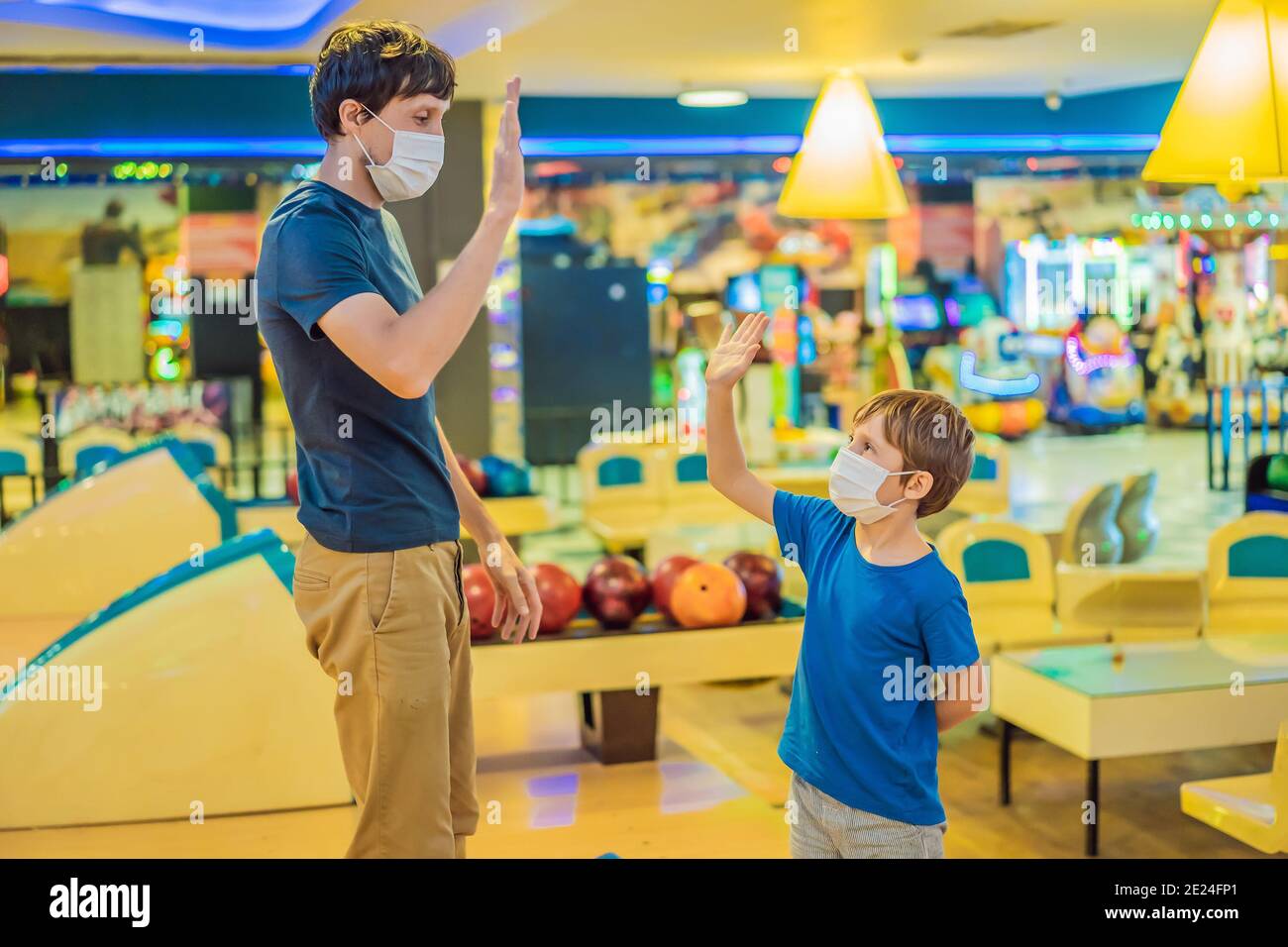 Father and son playing bowling with medical masks during COVID-19 ...