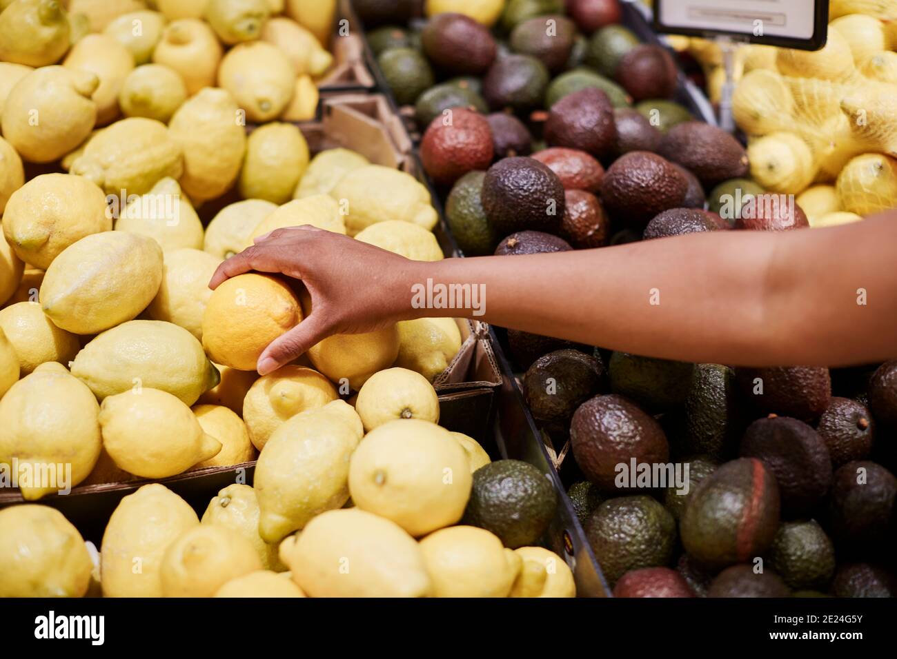 Hand choosing lemon in shop Stock Photo - Alamy