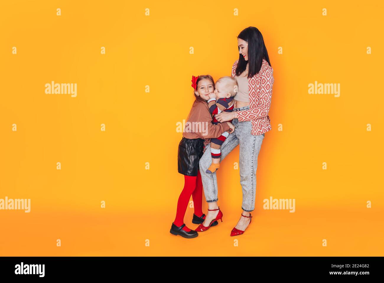 Mom with children in front of a yellow background. A happy family ...