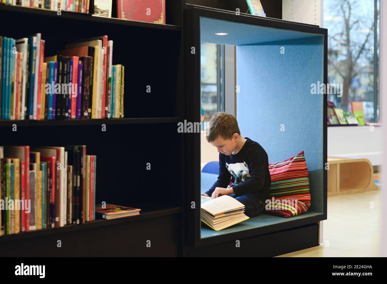 Boy reading in library Stock Photo - Alamy