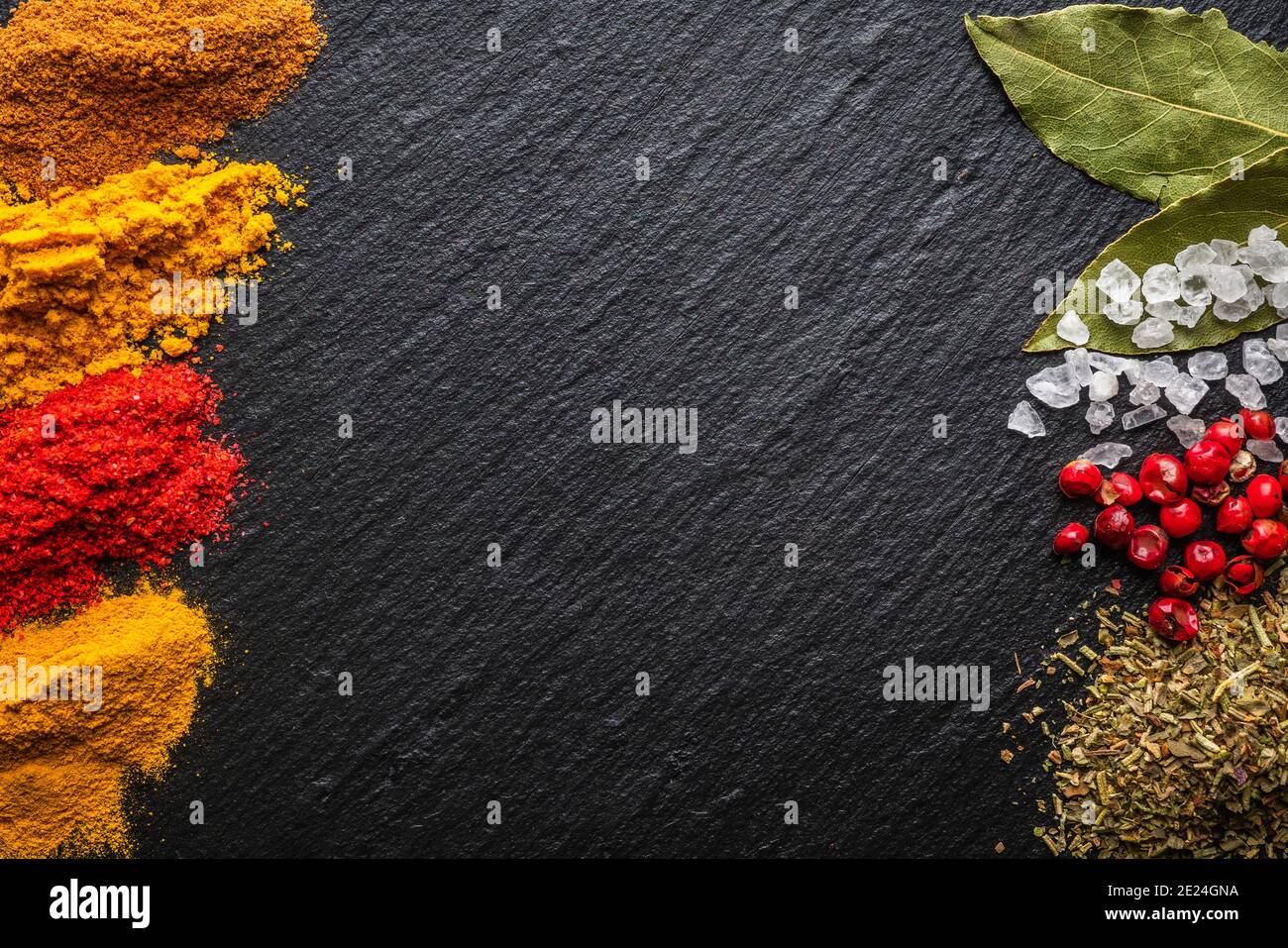 Bright and colorful spices on the black stone background. Different ...