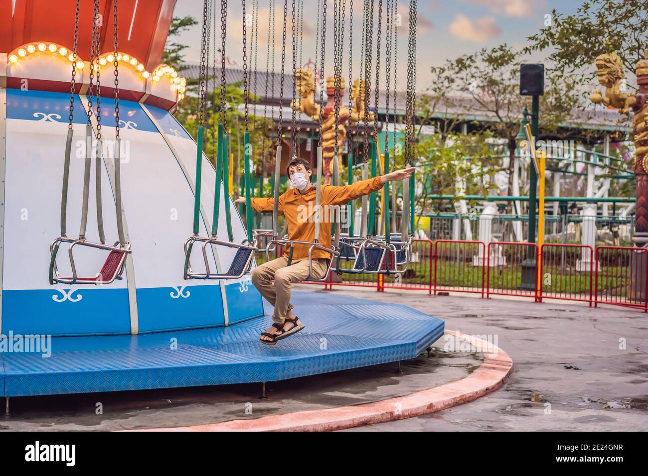Man riding a carousel wearing a medical mask during COVID-19 ...