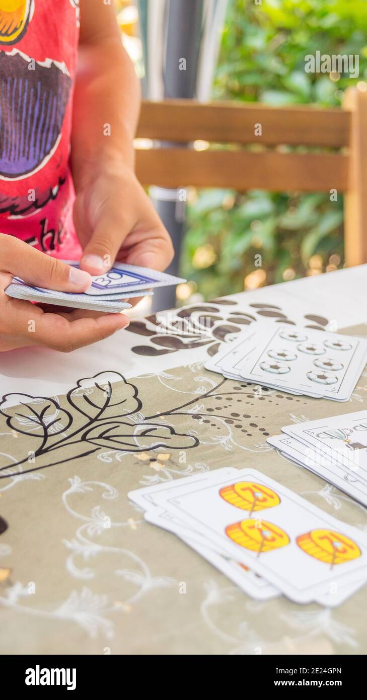 Vertical shot of hands distributing playing cards with sport theme ...
