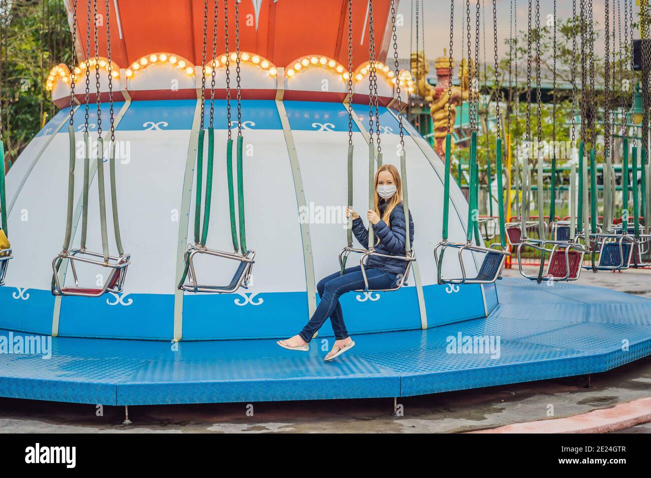 Woman riding a carousel wearing a medical mask during COVID-19 ...