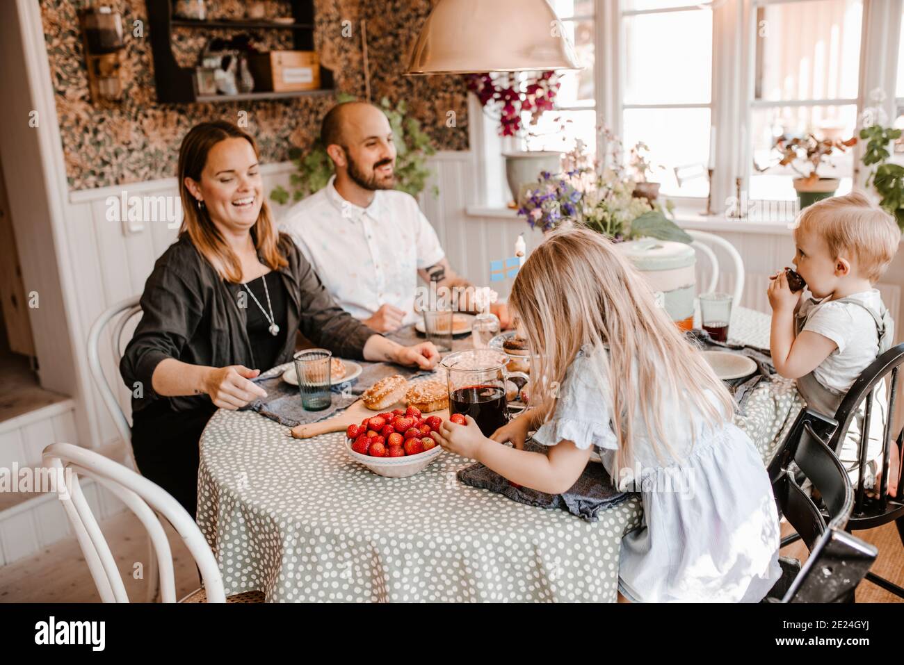 Smiling family having meal together Stock Photo - Alamy
