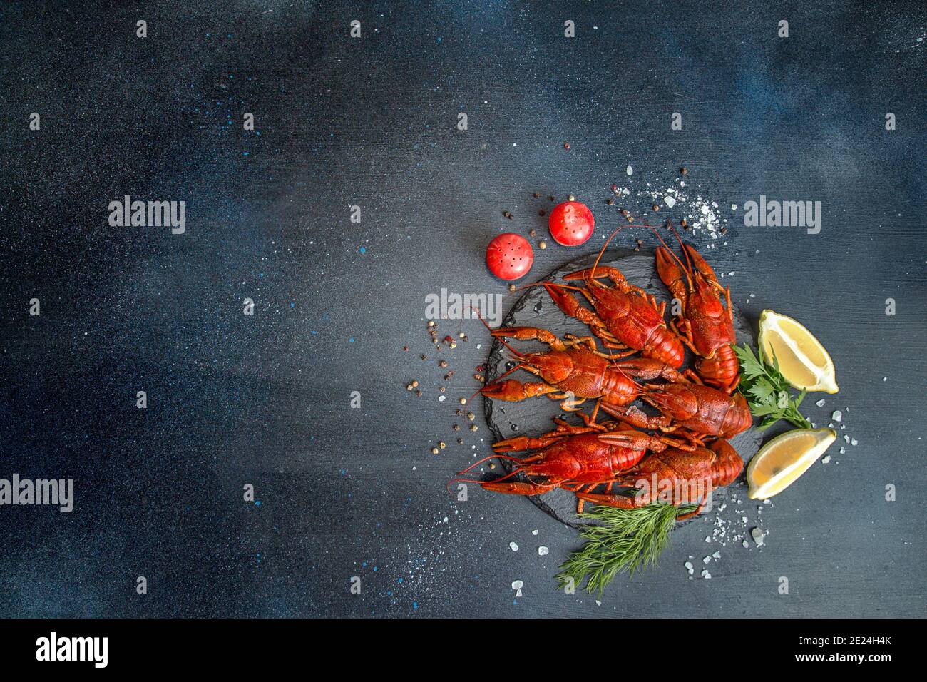Boiled cooked crayfish crawfish ready to eat on black deep blue ...