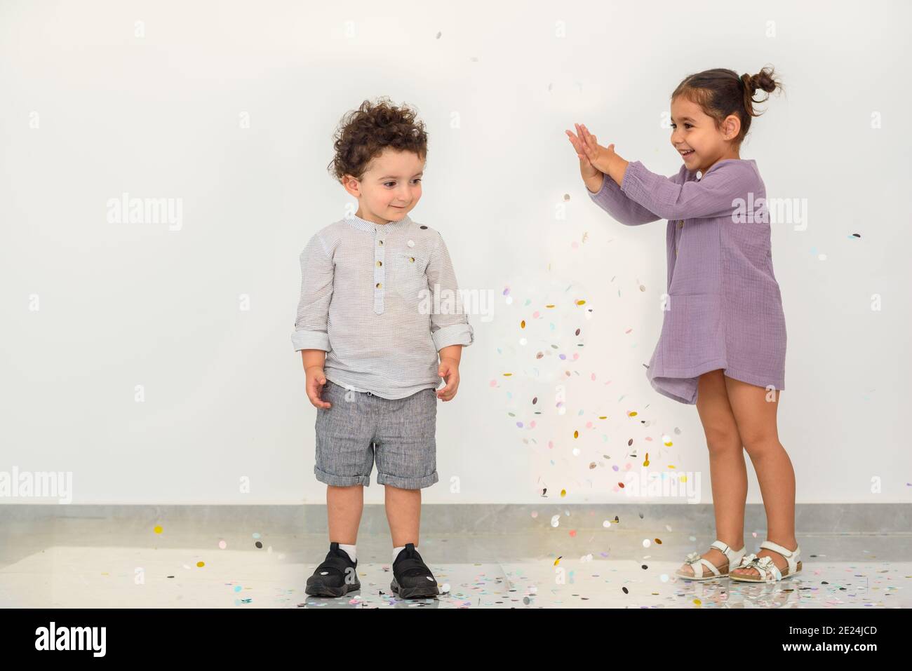 Happy funny kids with confetti on white background. Little boy having ...
