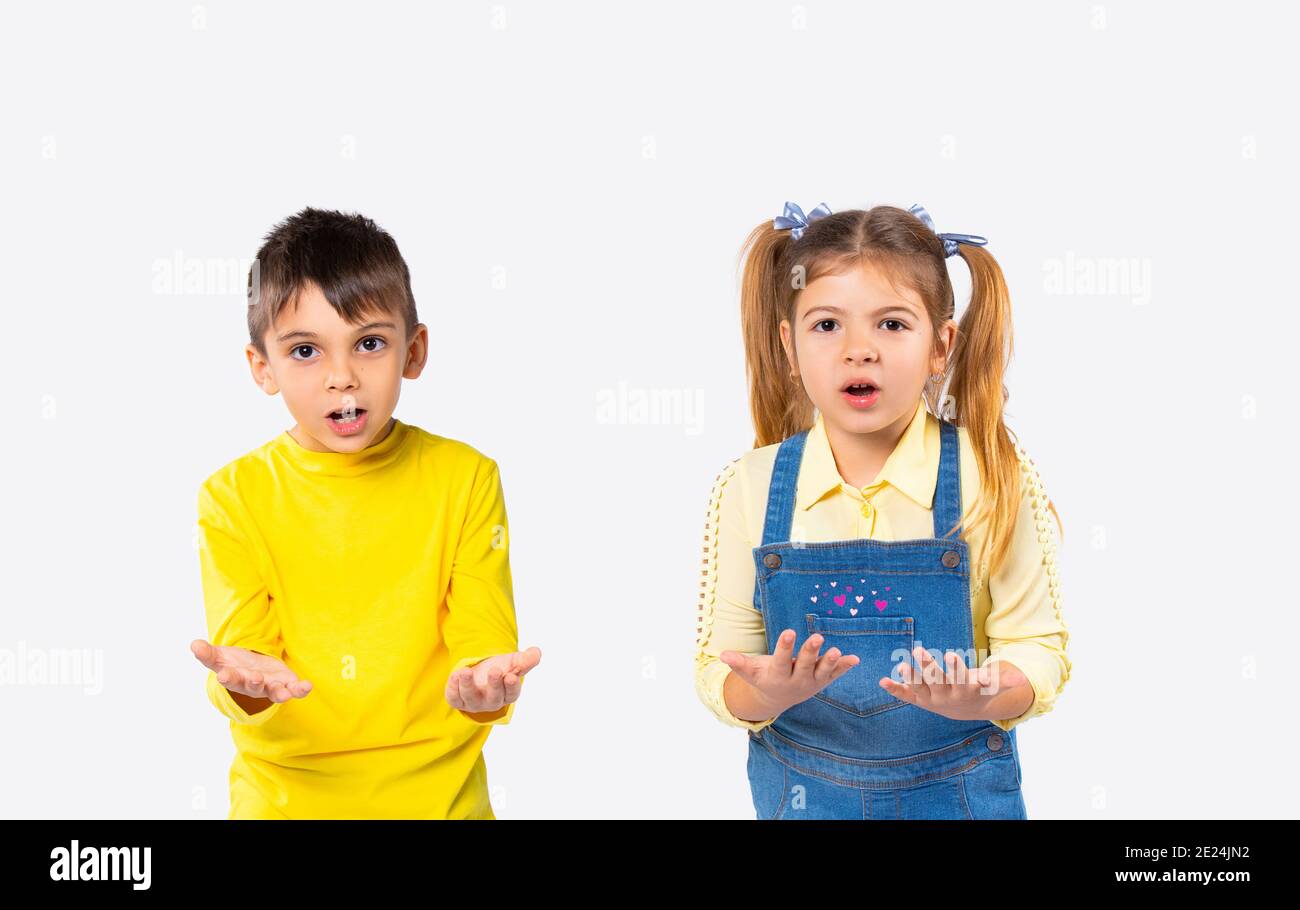 Surprised preschool children look at the camera with their arms ...