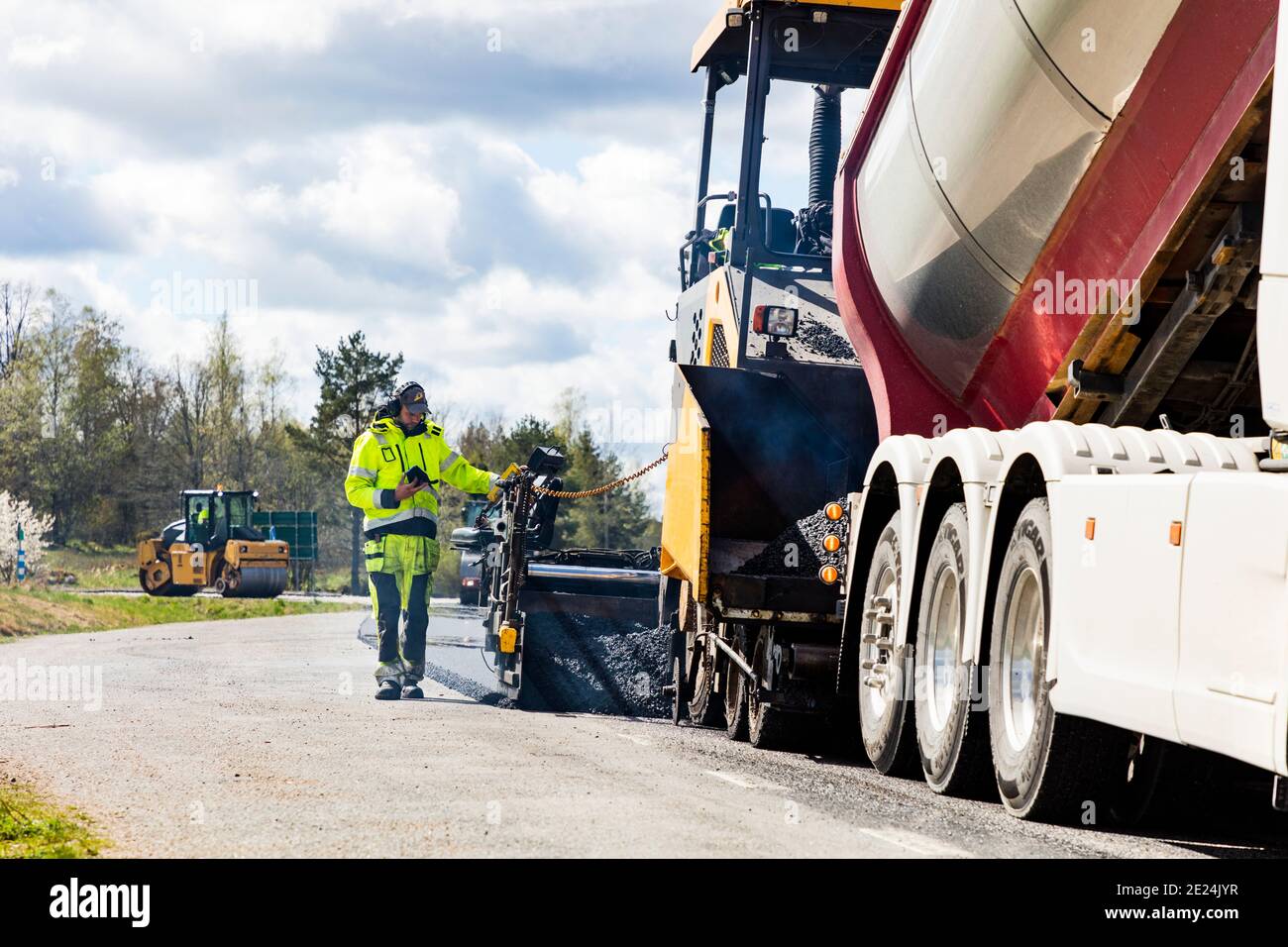 Man standing by asphalt paving machine Stock Photo - Alamy