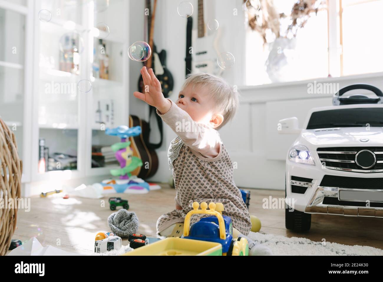 Toddler girl catching bubbles Stock Photo - Alamy