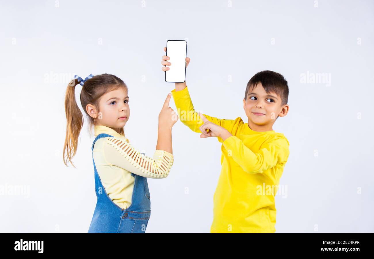 Preschool children on a white background point with a forefinger at the ...
