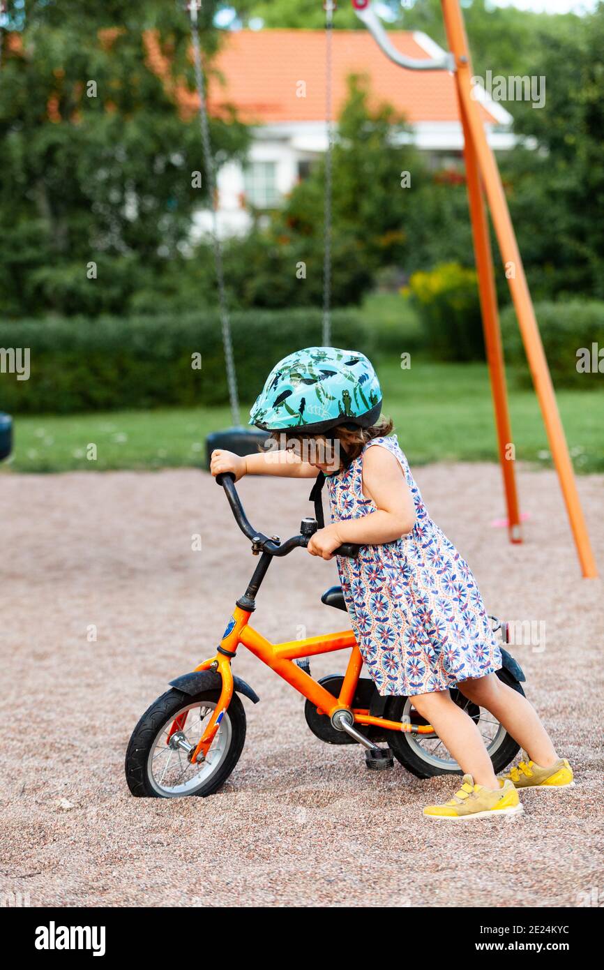 Girl pushing bicycle Stock Photo - Alamy