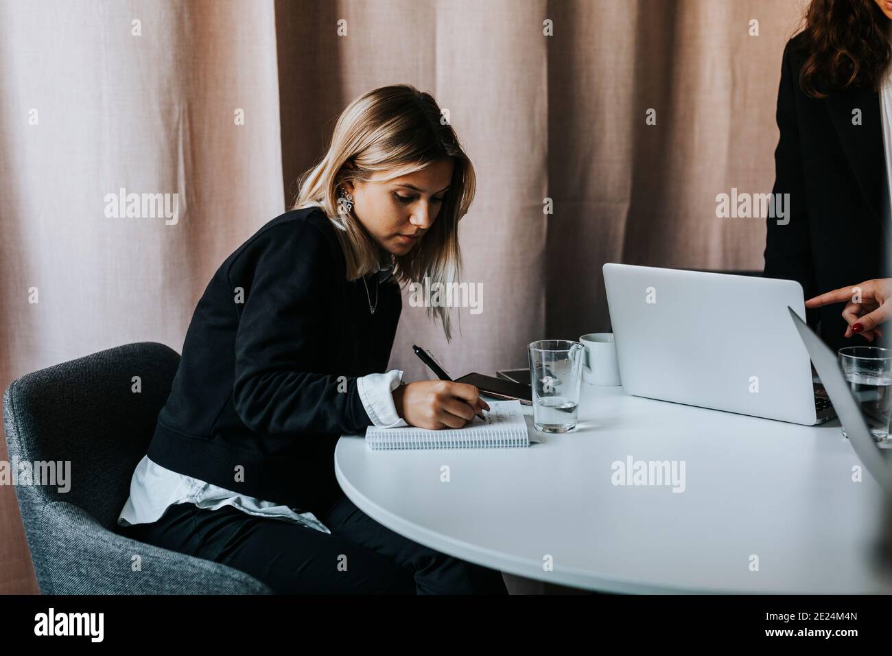 Woman in office taking notes Stock Photo - Alamy