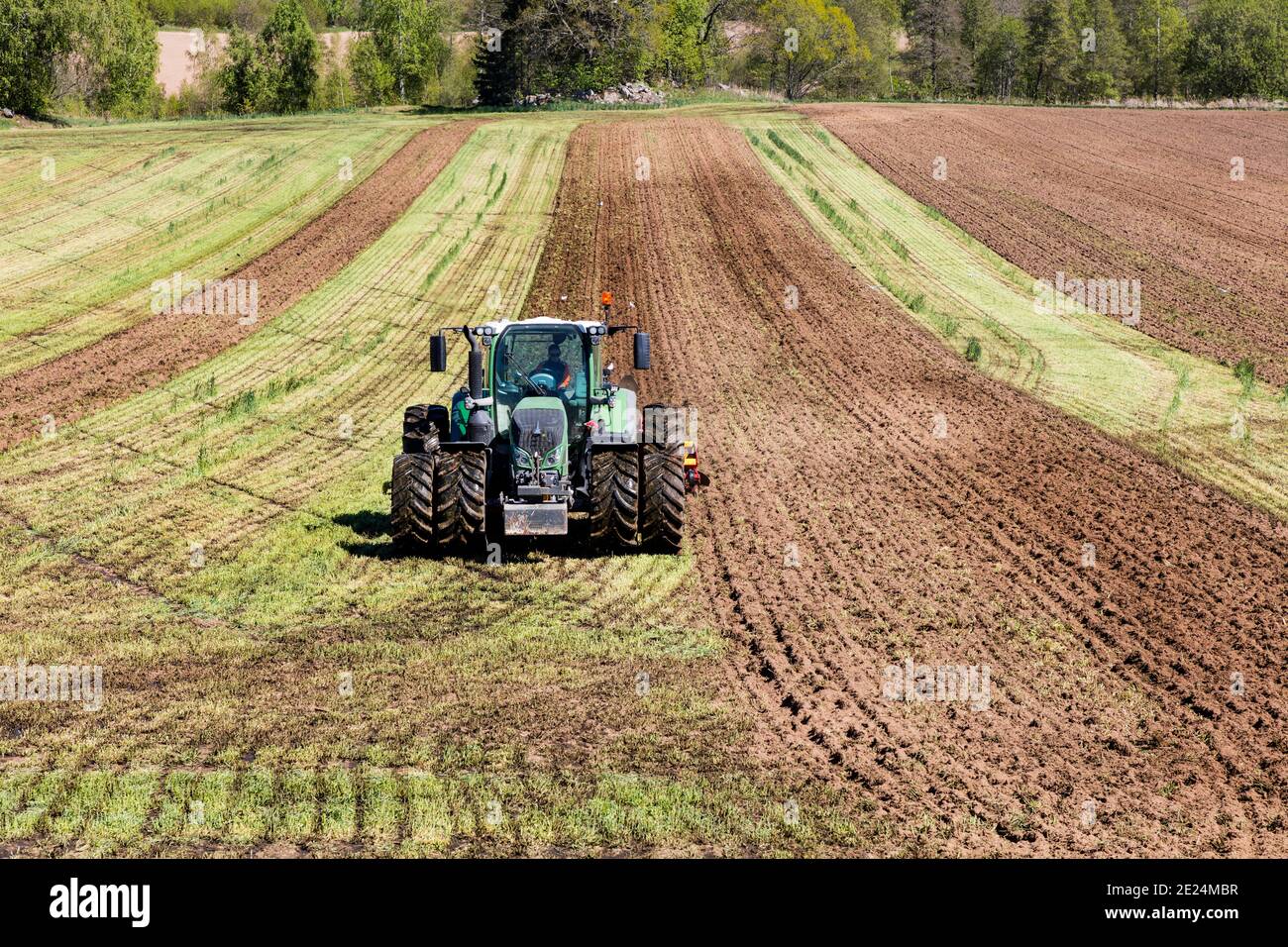 Tractor harrowing field Stock Photo - Alamy
