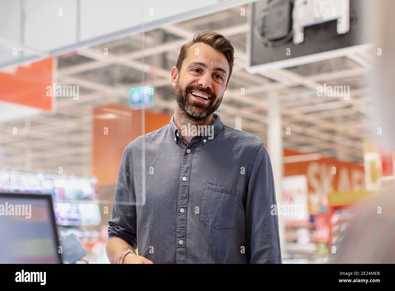 Smiling client at till Stock Photo - Alamy
