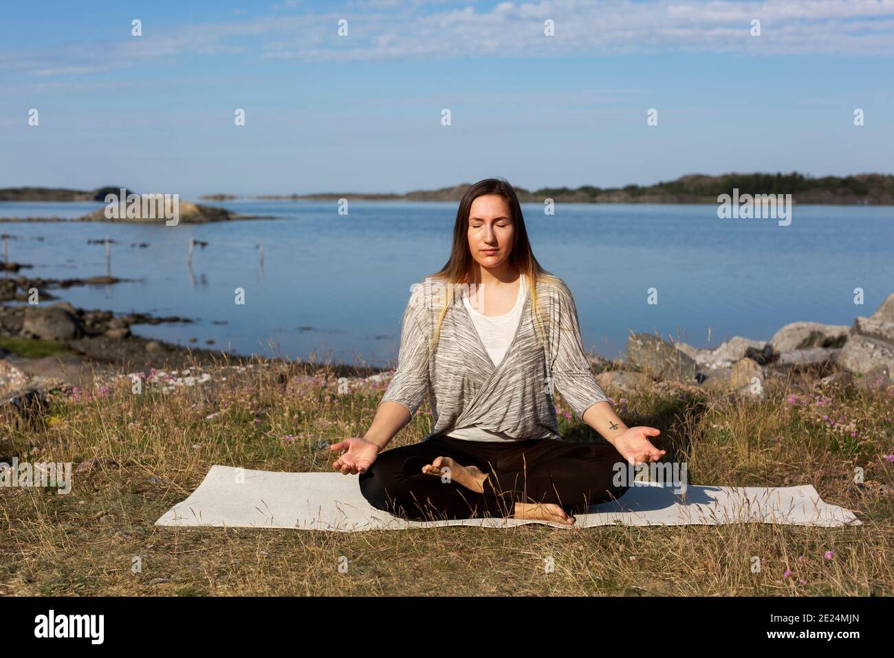 Woman meditating at sea Stock Photo - Alamy