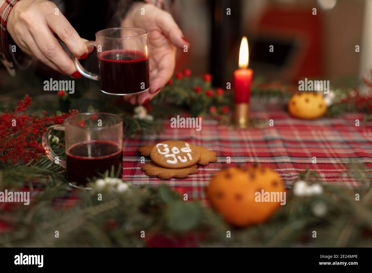 Womans hands holding glass with glogg Stock Photo - Alamy
