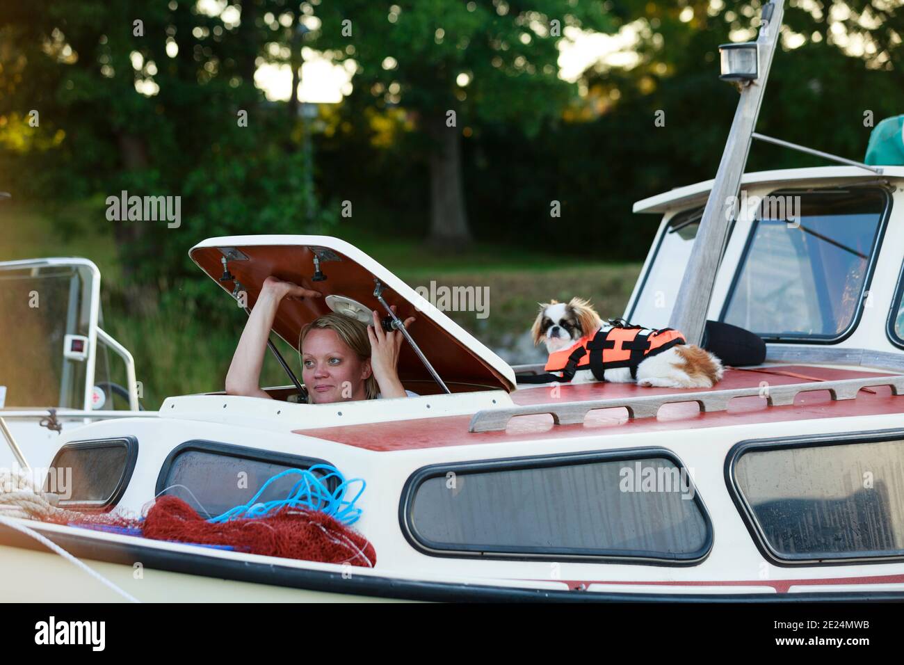 Woman on boat looking through hatch Stock Photo - Alamy