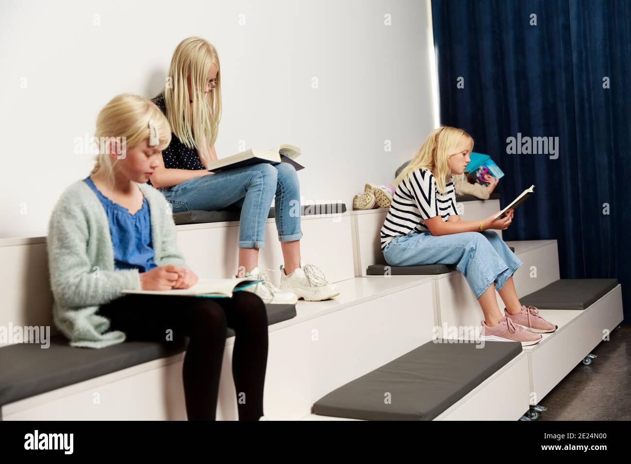 Girls reading in library Stock Photo - Alamy