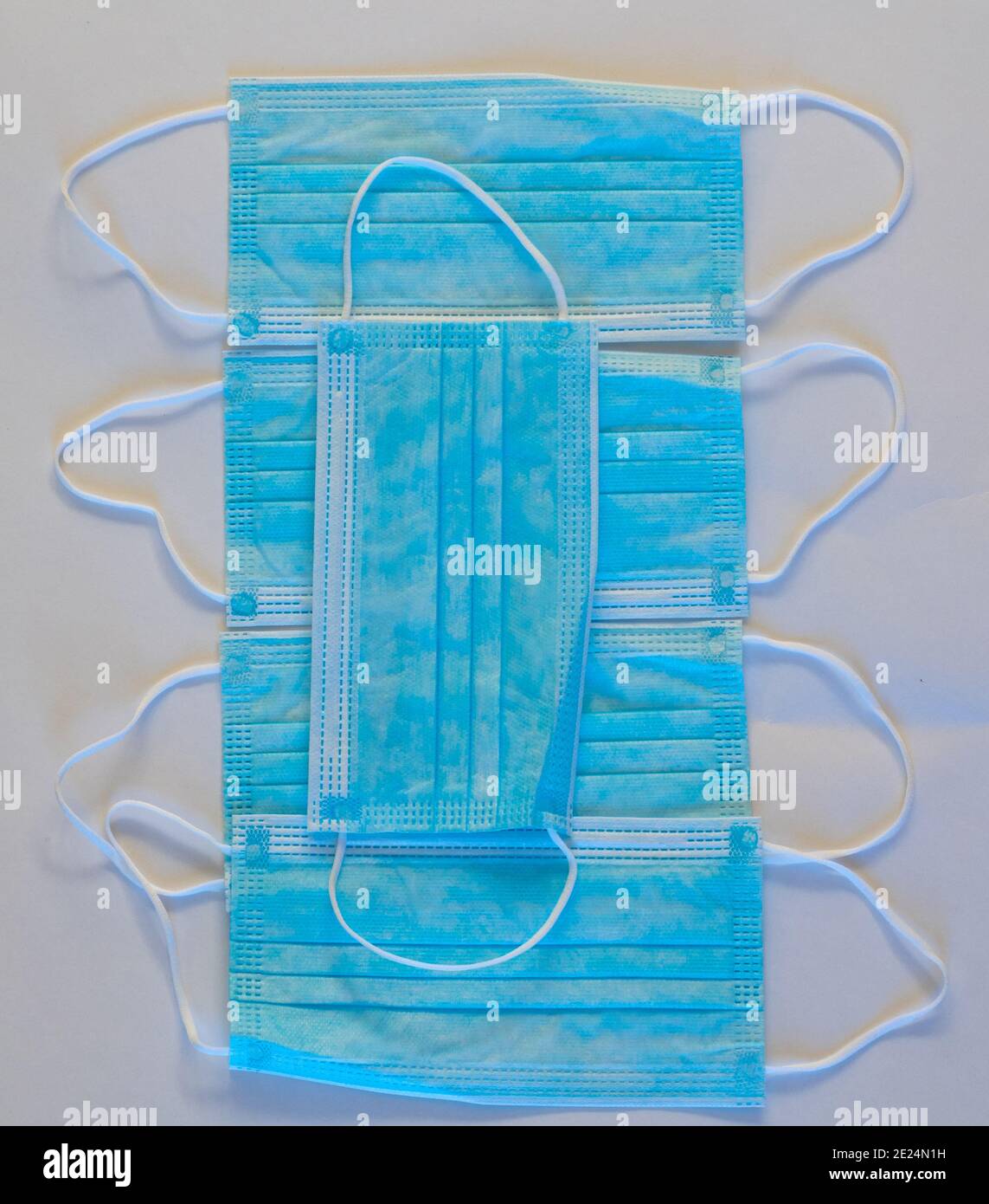 Overhead shot of several medical masks placed on each other with a ...