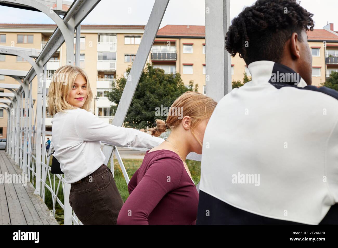 Young woman on bridge looking at camera Stock Photo - Alamy