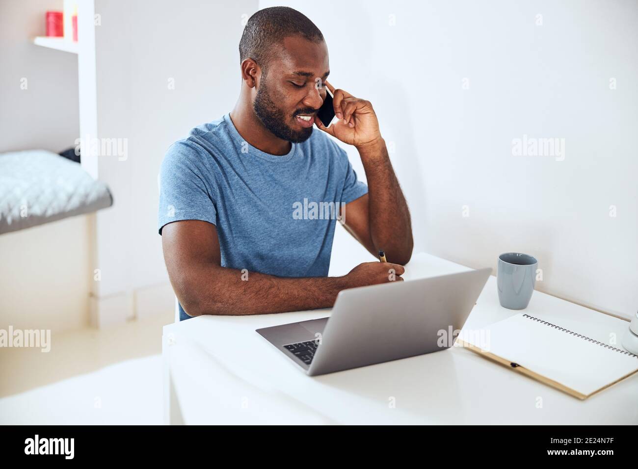 Worker noting down information from a phone chat Stock Photo - Alamy